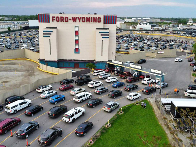Cars fill the massive lot at Ford-Wyoming Drive-In, creating a sea of vehicles all pointed toward the theater's impressive screens.