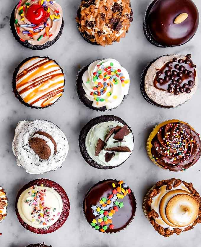 This cupcake lineup looks like a rainbow decided to become dessert, and honestly, good choice rainbow.