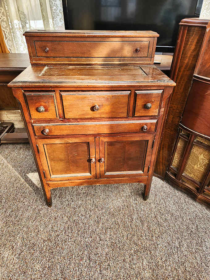 This handcrafted wooden cabinet has likely witnessed decades of family dinners and holiday gatherings before finding its way to this treasure-filled emporium.