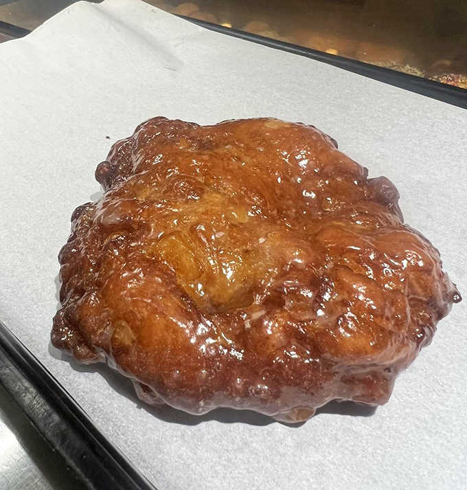 This isn't just an apple fritter &ndash; it's a monument to excess, a craggy landscape of caramelized dough and apple chunks that makes ordinary fritters weep with inadequacy.