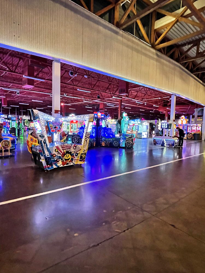 Neon lights illuminate acres of arcade games where quarters disappear faster than your resolution to "just play one."