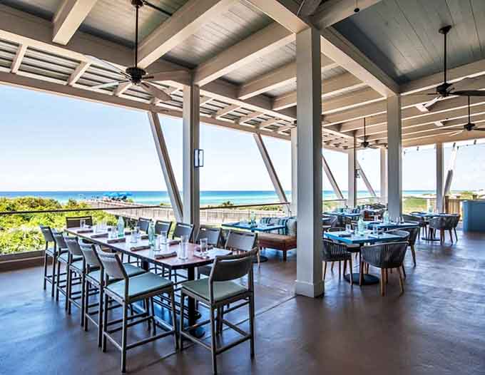 Al fresco perfection: Ocean breezes complement culinary creations at this elevated dining space where the Gulf becomes your dinner companion. 