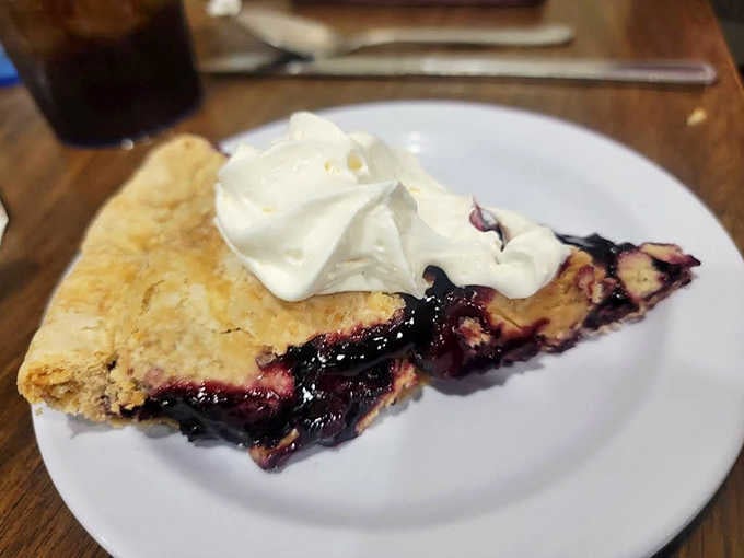 This black raspberry pie isn't just dessert, it's an experience &ndash; warm, juicy berries nestled under a cloud of fresh whipped cream.
