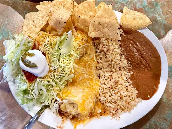 Behold the meat enchilada in all its glory, smothered in sauce and cheese perfection.