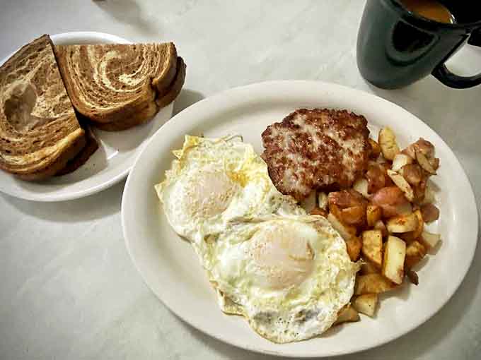 Two perfectly cooked eggs, golden hash browns, and a generous sausage patty prove that simple breakfast done right beats fancy brunch any day.