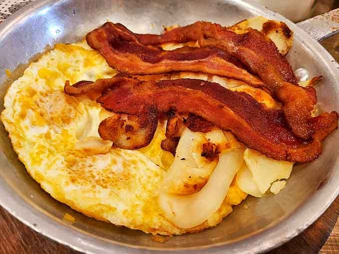 Golden hash browns meet perfectly cooked eggs and crispy bacon in a breakfast plate that defines morning perfection.