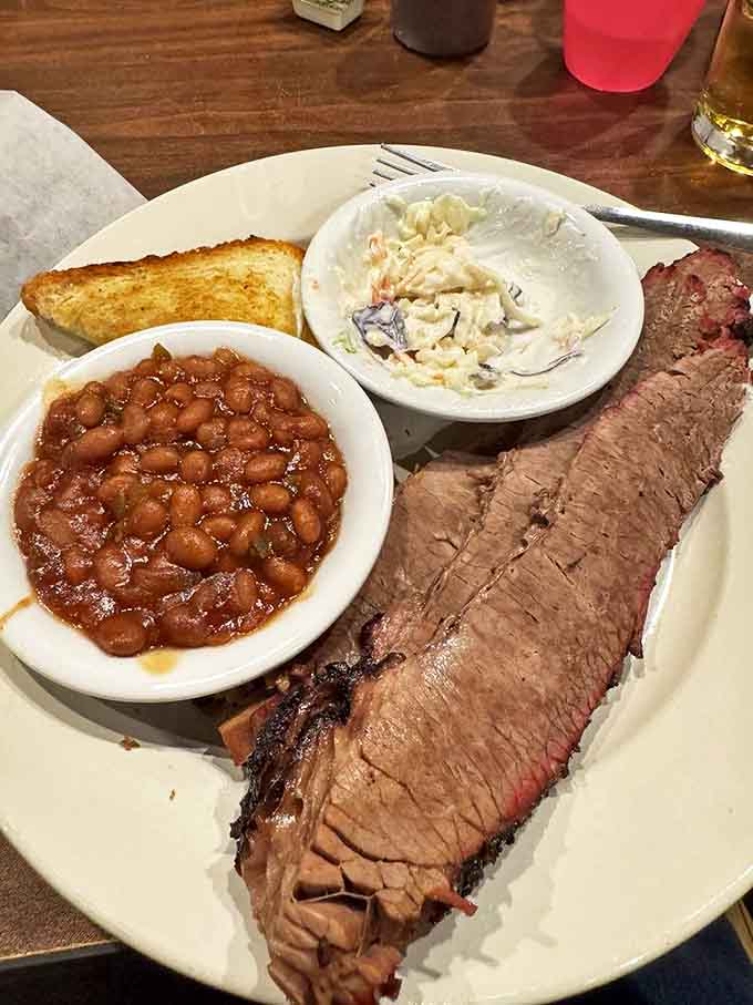 Brisket so tender it practically surrenders to your fork, paired with classic sides that prove barbecue is a complete culinary symphony.