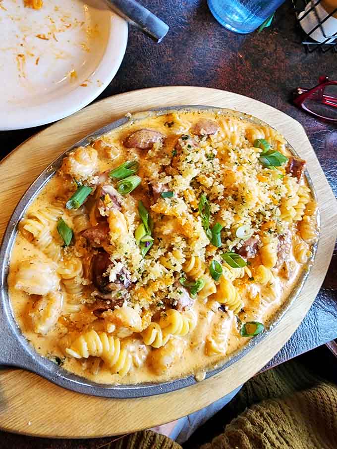 Golden, creamy mac and cheese arrives topped with breadcrumbs and fresh herbs, comfort food elevated to art.