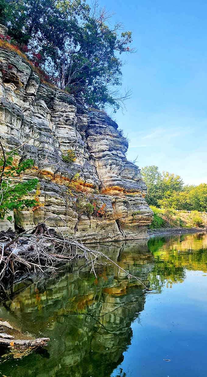 Towering limestone cliffs rise dramatically from the riverbank, creating the kind of scenery that makes you reach for your camera before you even realize it.