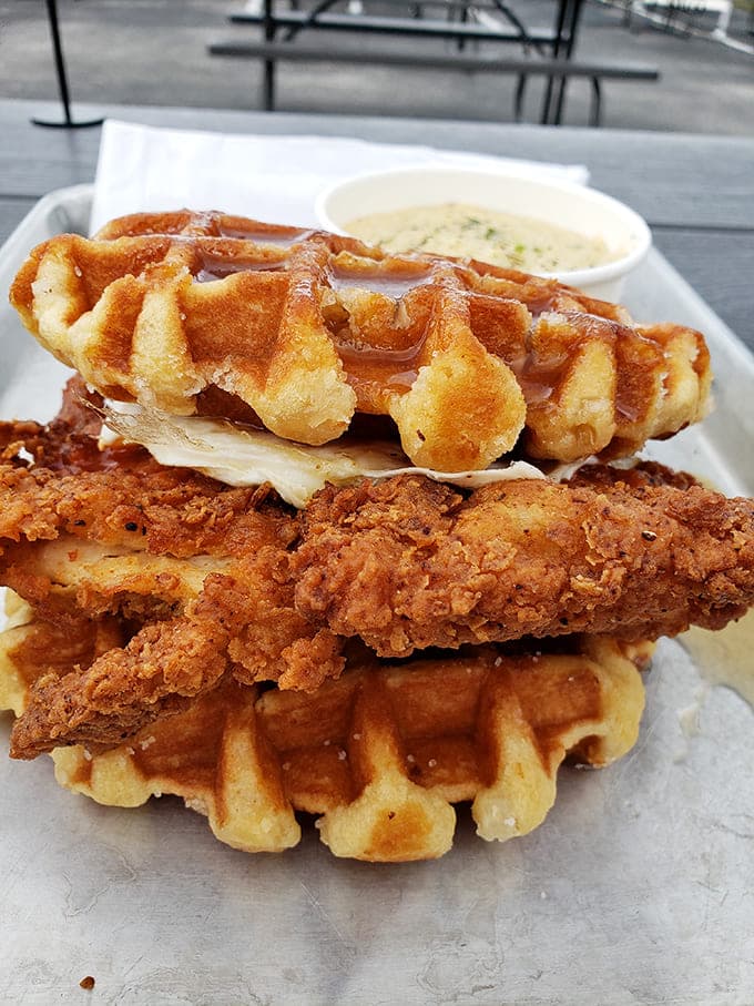 This isn't just a sandwich; it's a masterpiece of contrasts &ndash; crispy chicken embraced by golden waffles with maple syrup playing matchmaker.