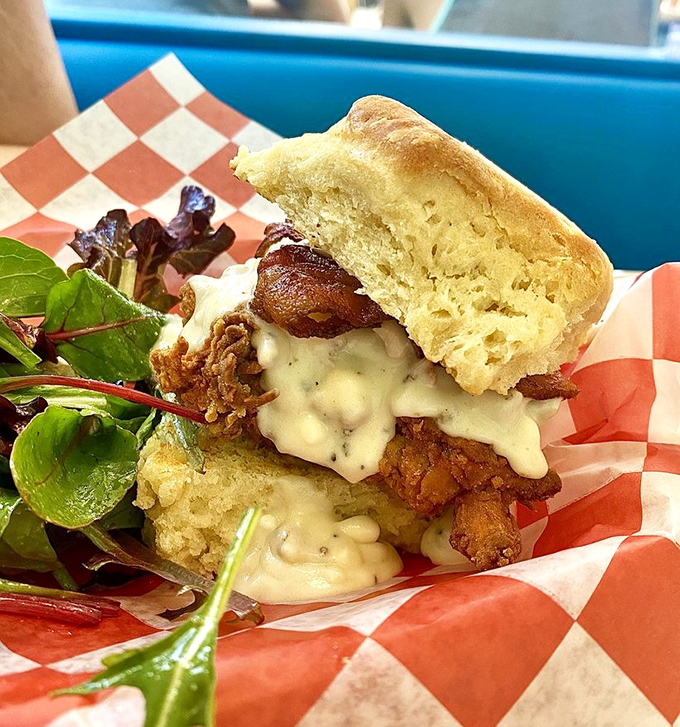 This isn't just a sandwich; it's architecture &ndash; layers of crispy chicken and melty cheese nestled between cloud-like biscuit halves.