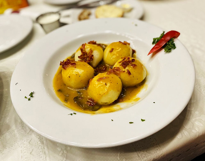 These aren't just dumplings; they're little potato-filled time machines transporting you to a Polish grandmother's kitchen with every buttery, bacon-topped bite.