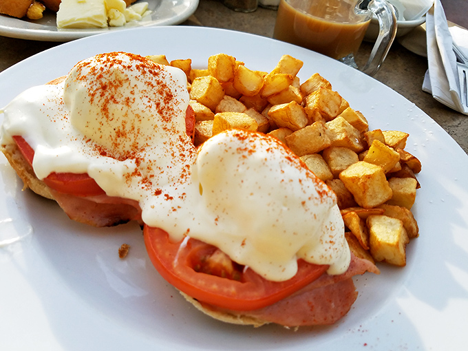 These Eggs Benedict aren't just breakfast – they're a religious experience. Perfectly poached eggs surrender their golden treasure over Canadian ham, all baptized in hollandaise heaven.