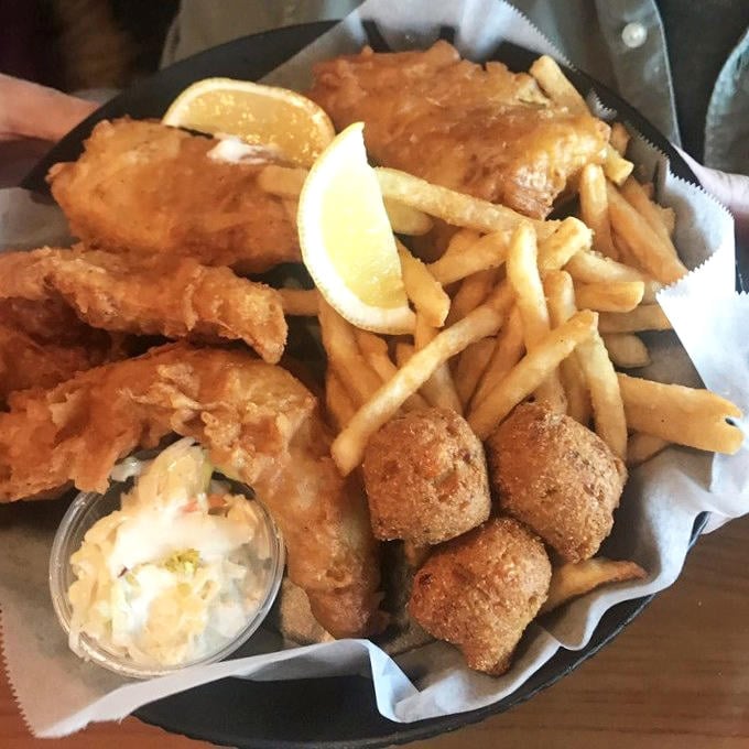 The fish fry platter arrives like a golden treasure chest, complete with crispy hush puppies and fries for days.