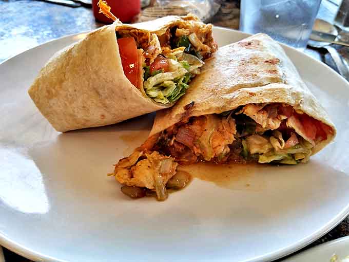 A perfectly wrapped gyro bursting with seasoned meat and fresh veggies, ready to transport your taste buds to Greece.