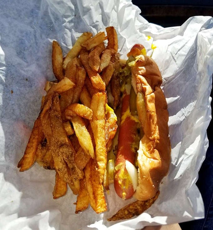 A perfect marriage: the legendary hot dog nestled in its paper wrapper with golden fries piled right on top &ndash; Chicago's ultimate power couple.