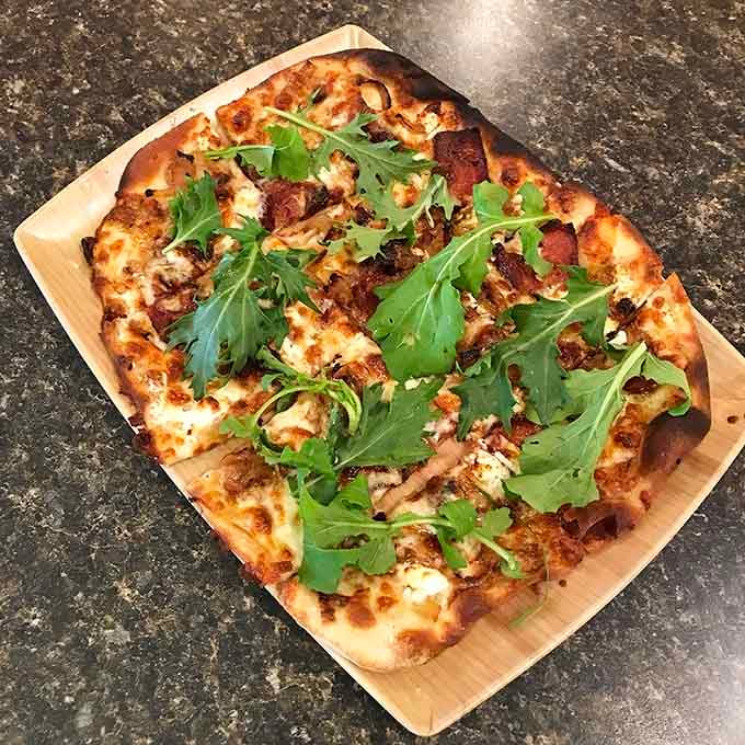 The Mediterranean flatbread pizza in all its glory, topped with arugula and ready to change your lunch plans.