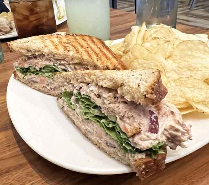 Behold the legendary tuna melt: crispy multigrain bread embracing perfectly seasoned tuna and melted cheese in harmony.