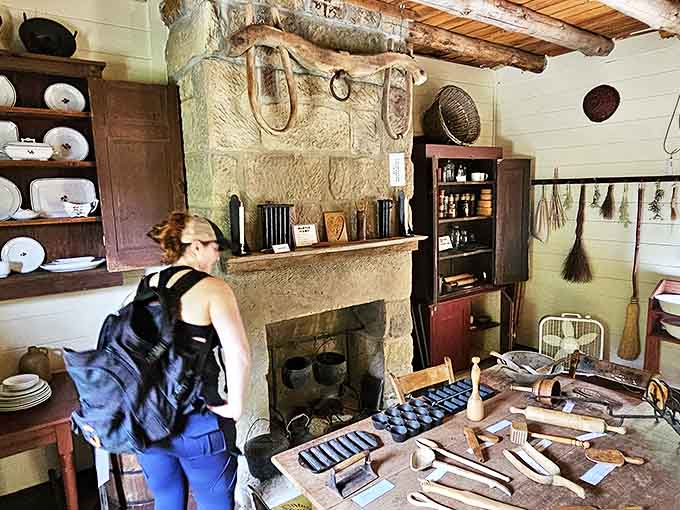 A visitor explores the historical kitchen, probably grateful she doesn't have to cook Thanksgiving dinner using those cast iron implements.