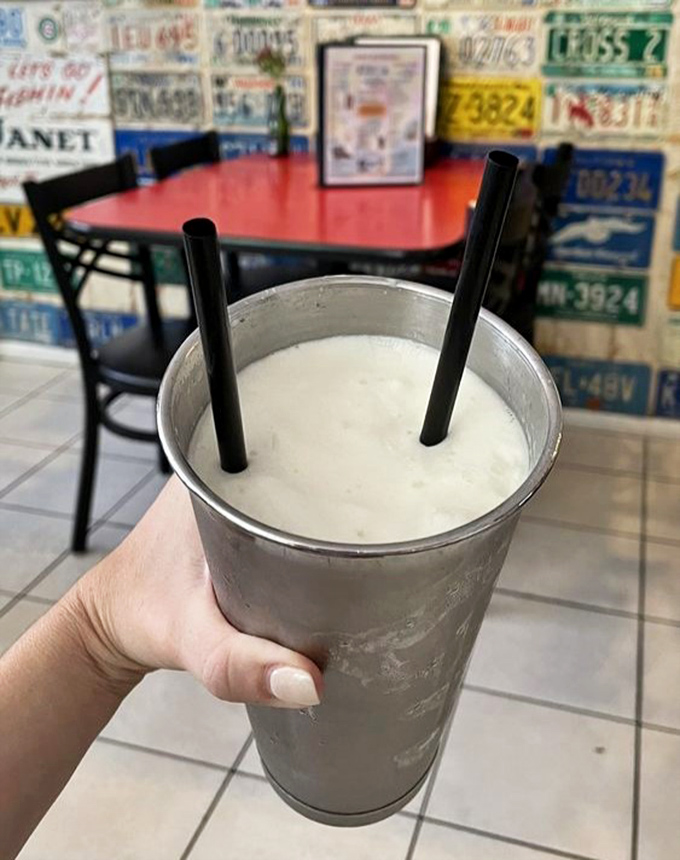 A frosty Key Lime milkshake awaits its lucky recipient, the metal cup sweating in anticipation of that first heavenly sip.