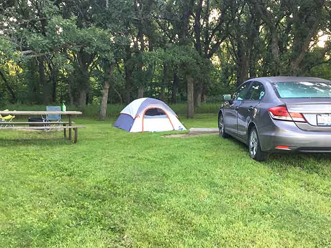 That tent setup looks more organized than most people's lives, complete with a car that's probably packed more efficiently than a Tetris game.
