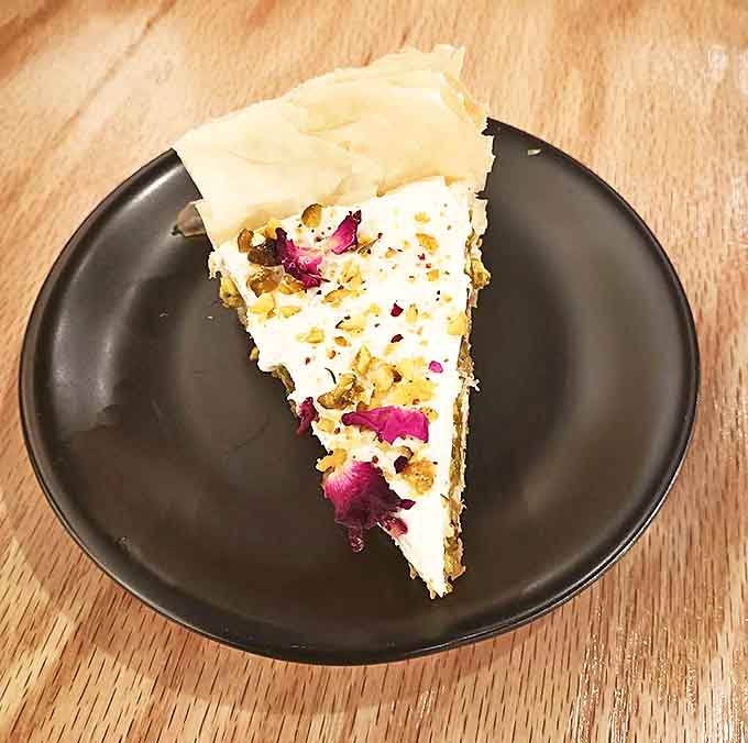 Layali Lubnan Cheesecake adorned with rose petals and pistachios – a dessert so beautiful you almost feel guilty destroying it with your fork. Almost.
