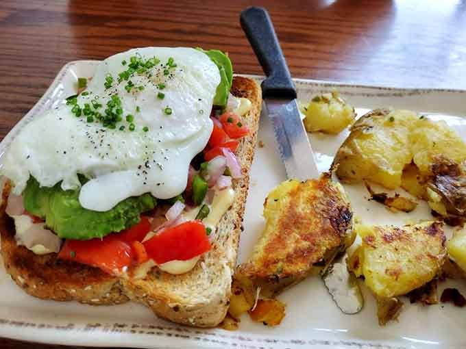 Behold the star of the show: avocado toast topped with a perfectly runny egg that's about to create pure breakfast magic on your plate.