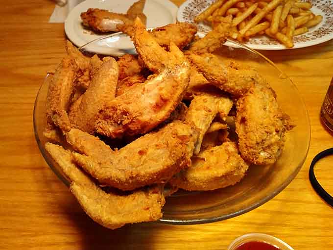 Golden, crispy wings stacked high like edible architecture, perfect for sharing or not sharing.