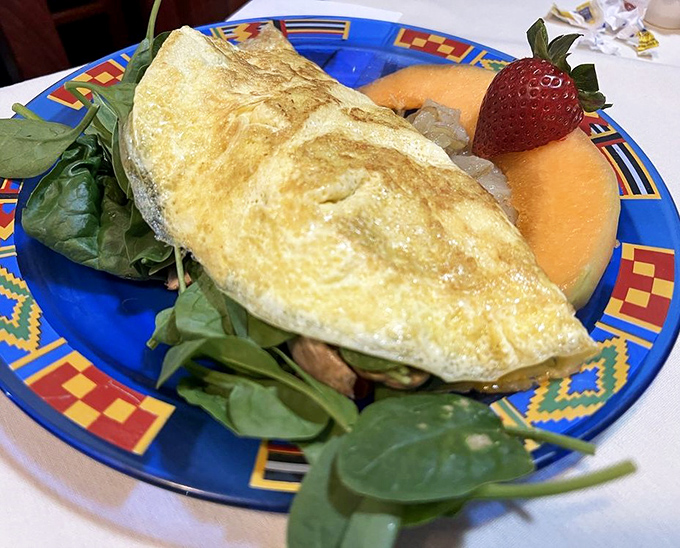 Golden, fluffy perfection on a colorful plate &ndash; this omelet comes with fresh spinach and seasonal fruit that brightens both the plate and your morning.