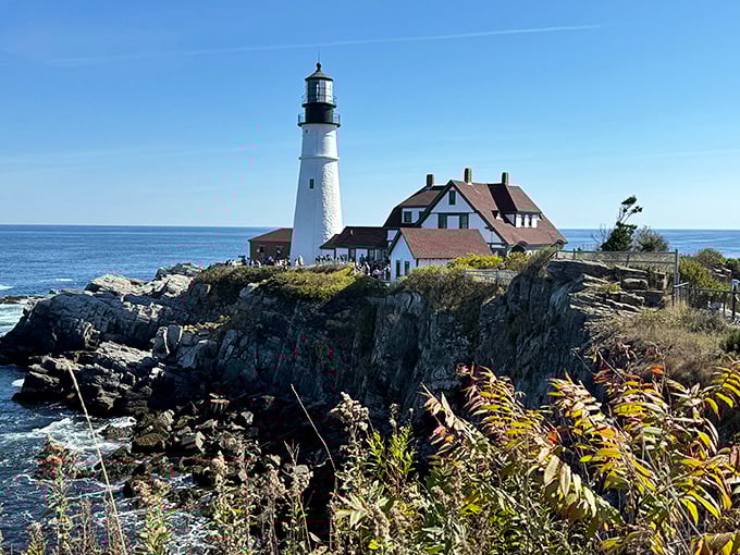 Portland Head Light stands majestically on rocky cliffs, its white tower and keeper's house a postcard-perfect Maine coastal scene.