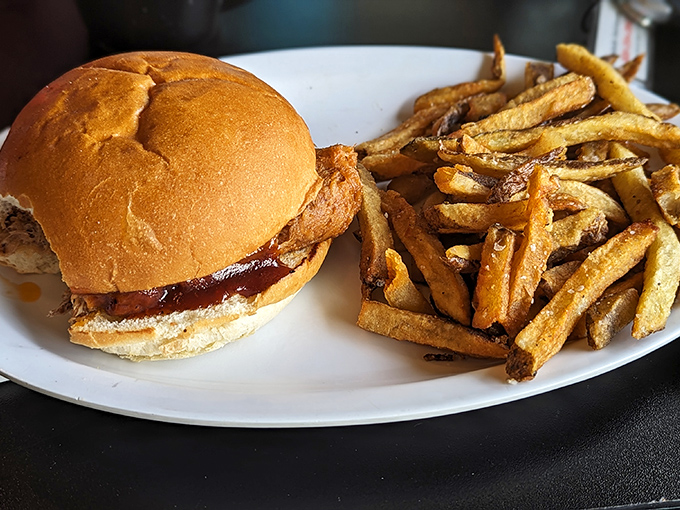 Tender, slow-cooked pork nestled in a pillowy bun with golden fries &ndash; a handheld masterpiece worth the napkin investment.