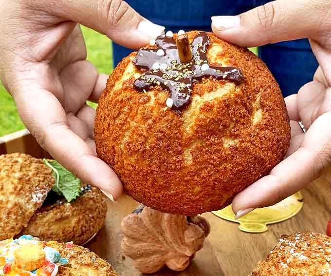 This pumpkin cream puff isn't just seasonal &ndash; it's a revelation of fall flavors encased in a golden shell that shatters with delightful precision.