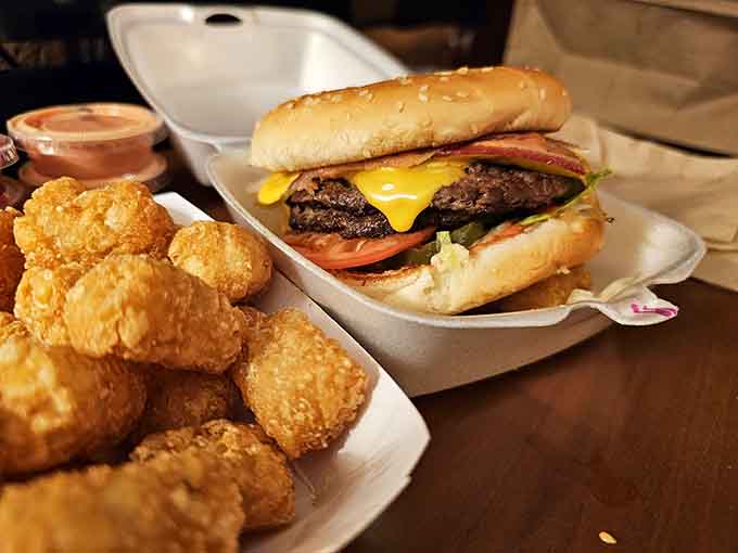 Behold the bacon cheeseburger in all its glory, with golden tots standing guard like crispy little soldiers of flavor.