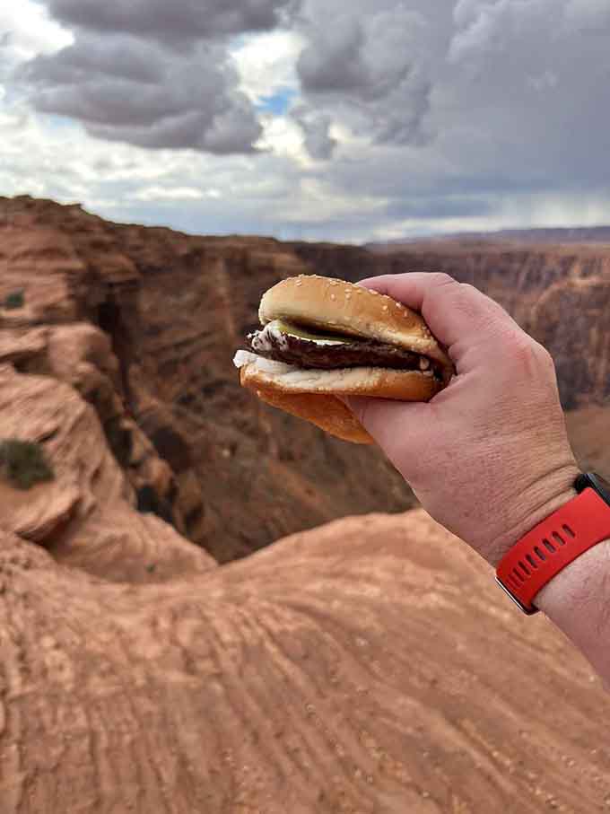 Behold the Green Chile Cheeseburger in its natural habitat, looking absolutely perfect against Arizona's stunning canyon backdrop like some delicious mirage.