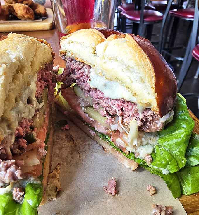 This isn't your average burger &ndash; it's a masterpiece of medium-rare perfection nestled in a pillowy brioche bun, demanding to be devoured between high-score attempts.