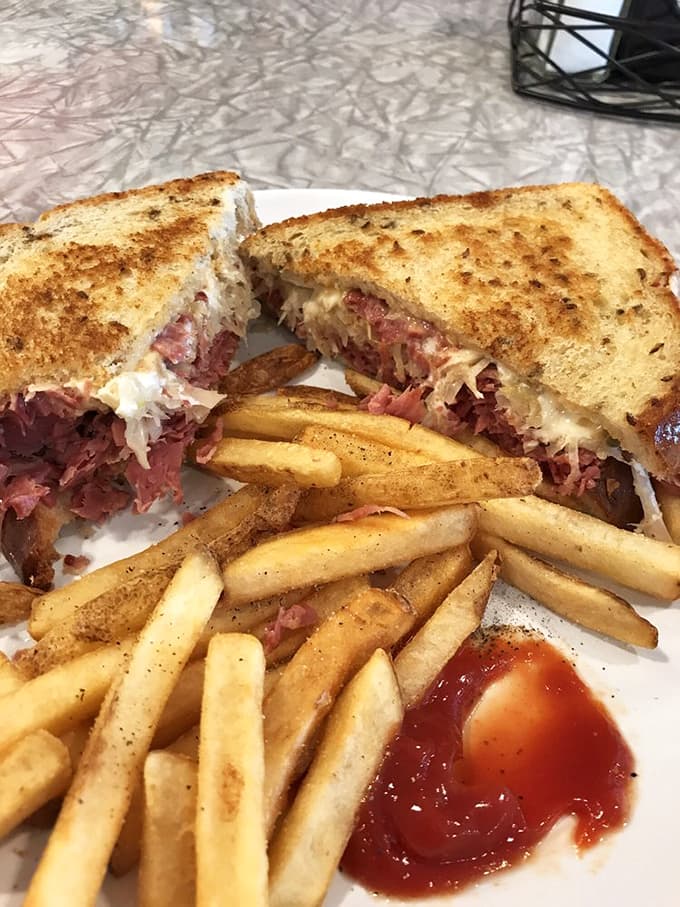 Behold the Reuben in all its glory, piled high with corned beef and paired with perfectly seasoned fries that deserve their own fan club.