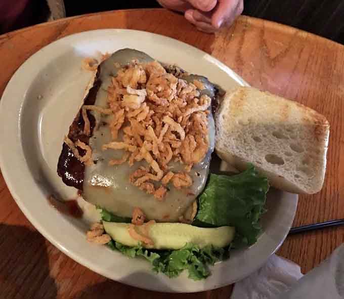 Behold the legendary meatloaf sandwich, crowned with crispy onions and ready to change your life, one savory bite at a time.