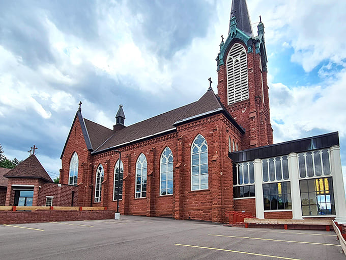 Saint Ignatius Loyola Catholic Church reaches skyward with its distinctive red brick spire, a spiritual landmark visible throughout downtown Houghton.