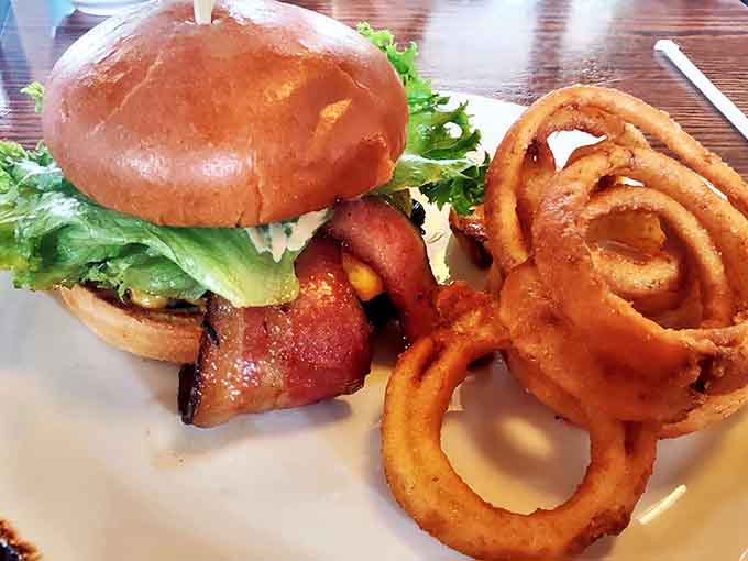 This isn't just a sandwich &ndash; it's an architectural marvel of crispy bacon, fresh lettuce, and golden onion rings.