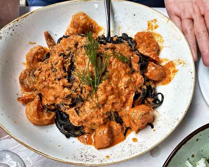 Behold the famous squid ink pasta in all its dramatic, jet-black glory, looking like edible art on a plate.