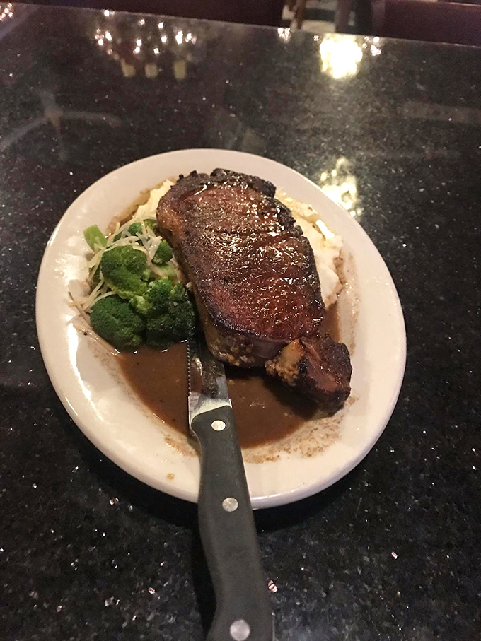 This perfectly seared steak rests on a cloud of mashed potatoes, accompanied by vibrant broccoli &ndash; proof that simple ingredients become extraordinary in skilled hands.