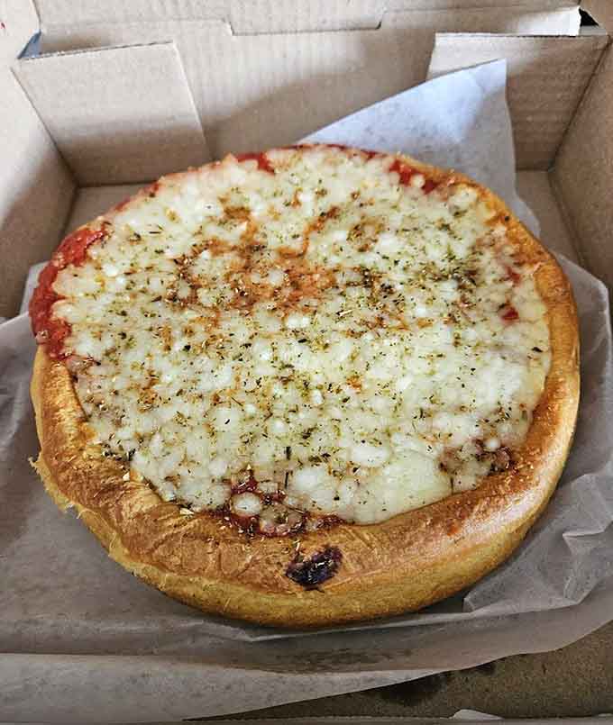 Behold the deep dish masterpiece, where golden crust meets a blanket of melted cheese in perfect harmony.