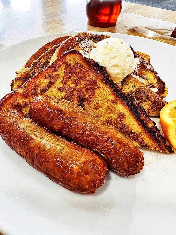 Texas-sized French toast that makes regular French toast look like an appetizer. That melting butter pat is performing a slow, delicious dance.