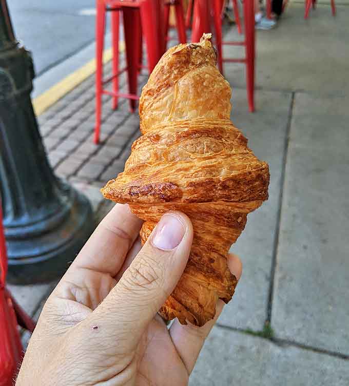 Golden, flaky, and more layered than a French art film&mdash;this croissant isn't just breakfast, it's a buttery masterpiece held by lucky fingers.