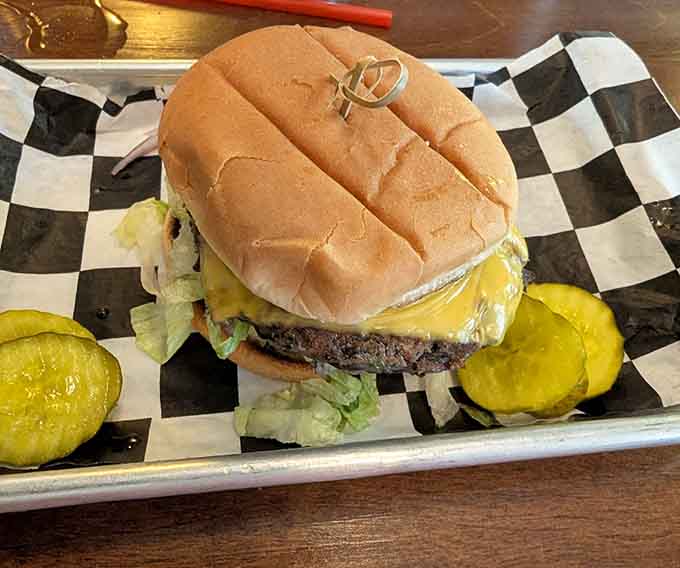 Behold the Malt Shop Burger in all its glory: melted cheese, crispy pickles, and that signature aioli creating pure handheld happiness.