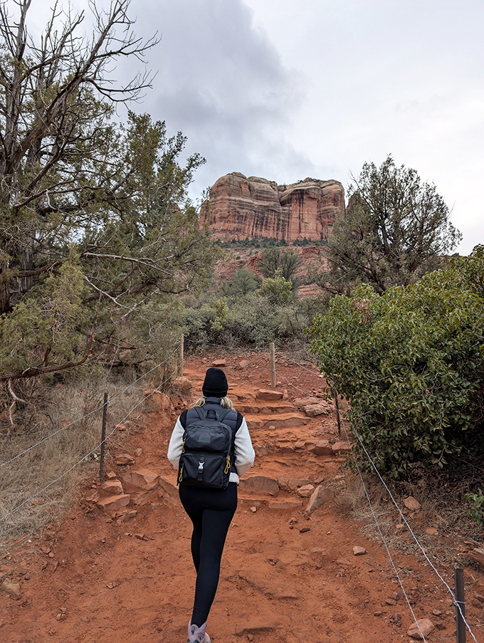 The journey begins with anticipation, each step on the rust-colored trail bringing you closer to views that defy description.