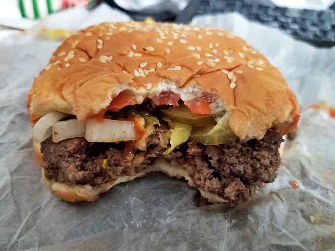 Behold the burger in its natural habitat, a juicy patty nestled on a sesame seed throne with fresh veggies standing guard. One bite explains the legend.