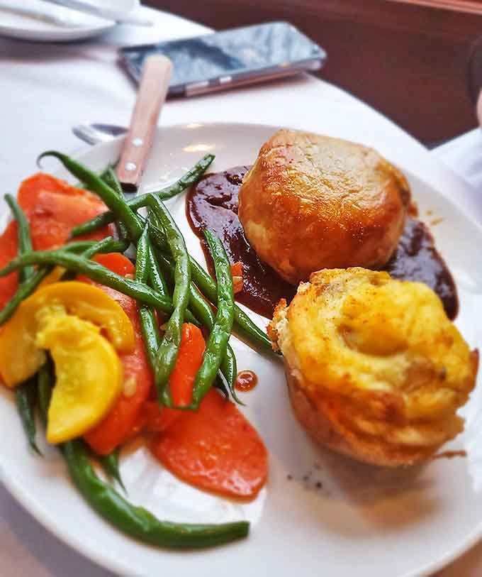 The crown jewel arrives &ndash; golden pastry encasing perfectly pink beef, a cross-section revealing the kitchen's architectural mastery.