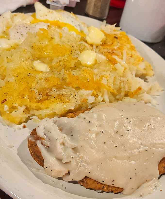 Country fried steak meets its perfect match in golden hashbrowns, creating a breakfast plate that understands the assignment completely.