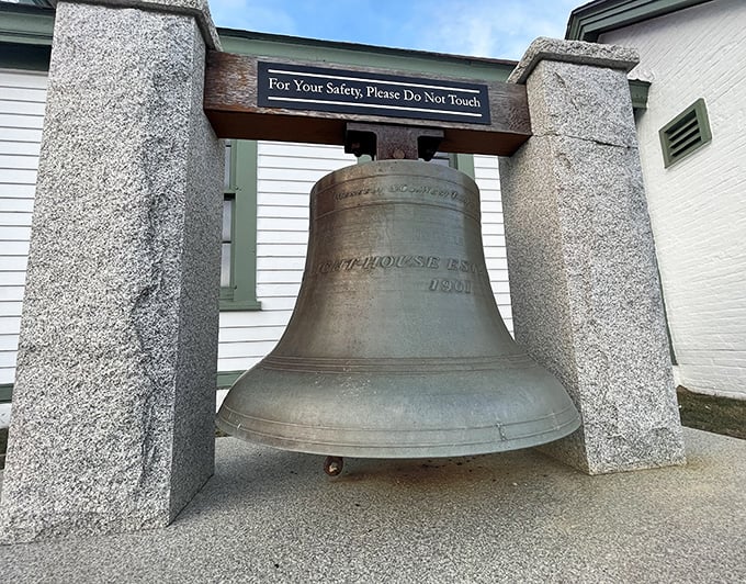 The historic lighthouse bell, silent now but once vital to mariners, stands as a tangible reminder of Portland Head Light's life-saving legacy.